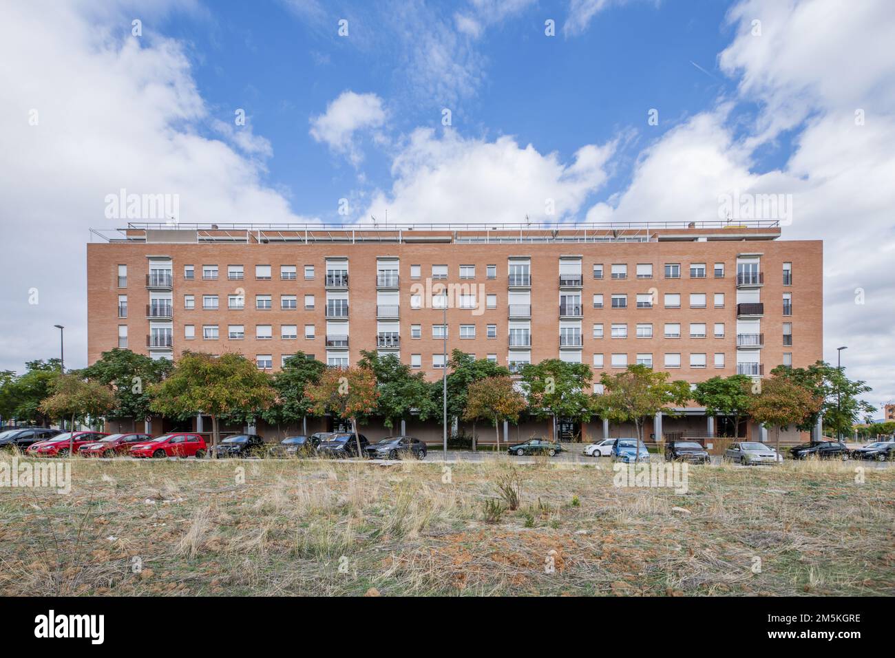 Facade Of A Lonely Apartment Building With Trees On A Day Of Blue Skies With Some Clouds Stock