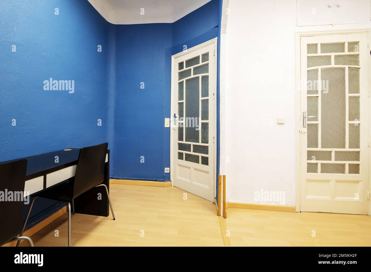 A room with old solid wood doors with translucent windows, blue and ...