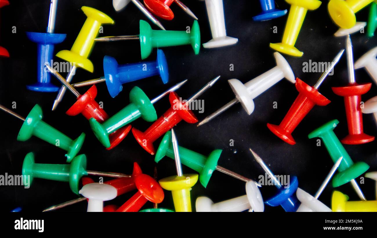 colorful thumbtacks on black background Stock Photo - Alamy