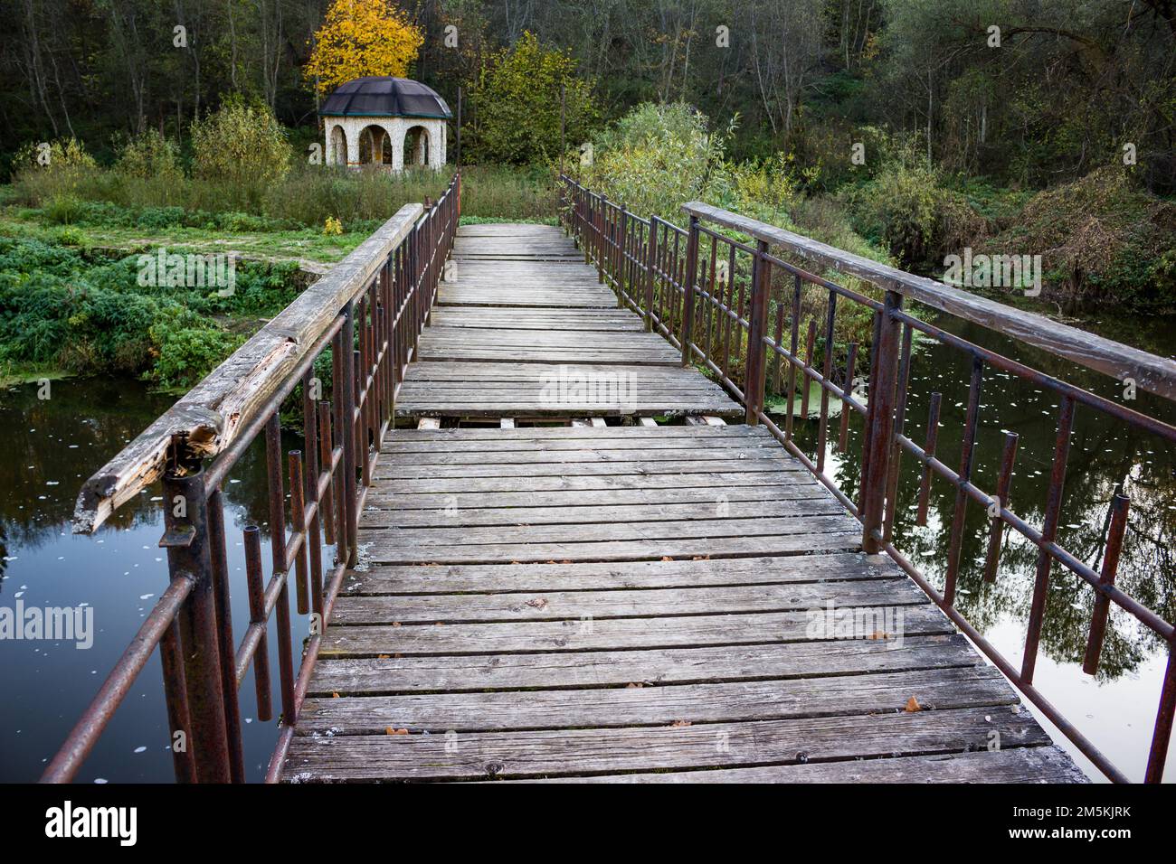 Metal pedestrian bridge with wooden deck across the Nara River, Russia ...