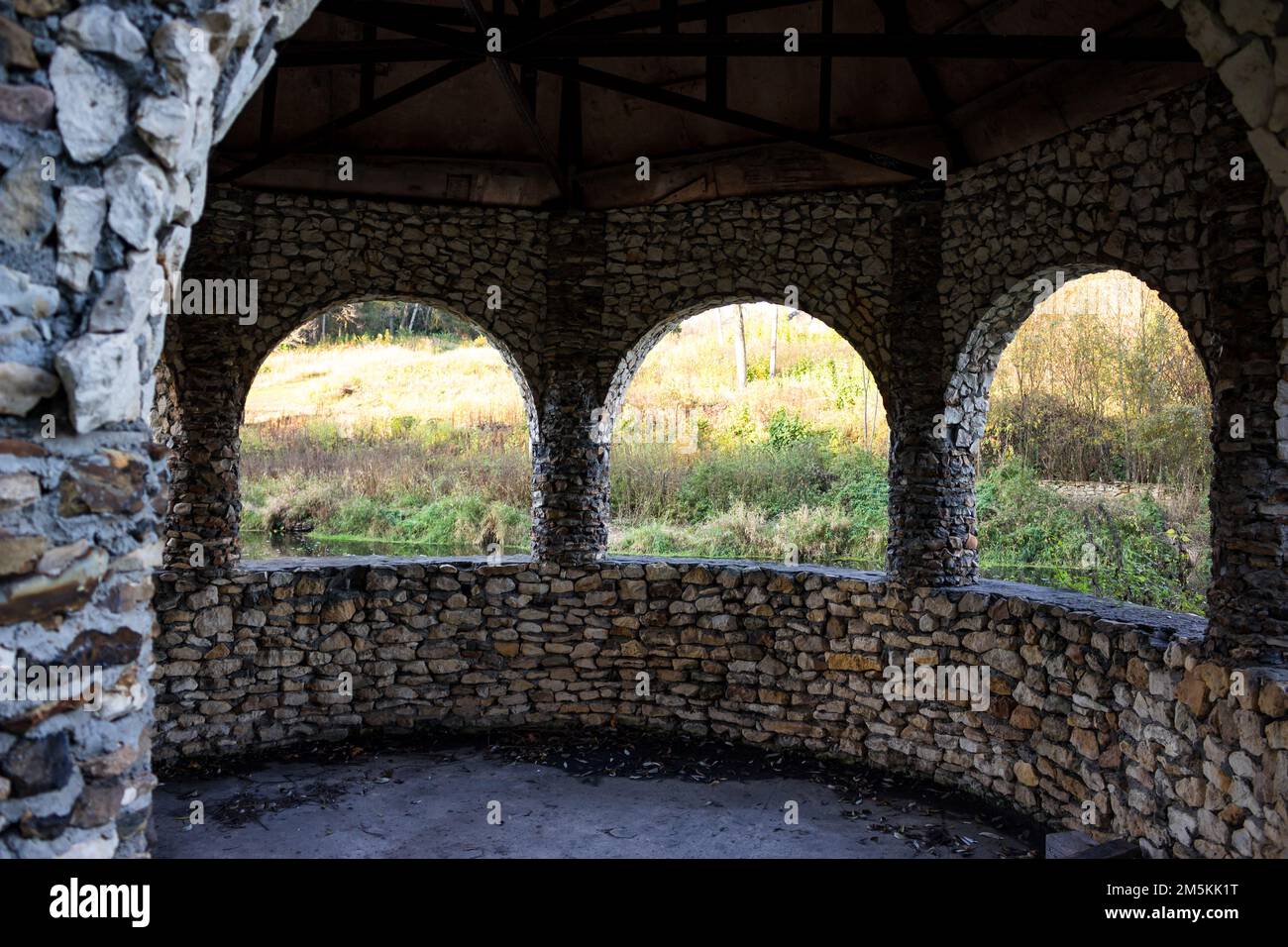 Park rotunda built from fragments of stone with columns and arched ...