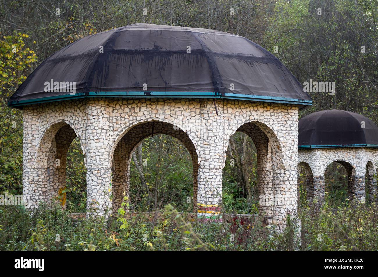Park gazebos with arched windows made of raw natural stone Stock Photo ...