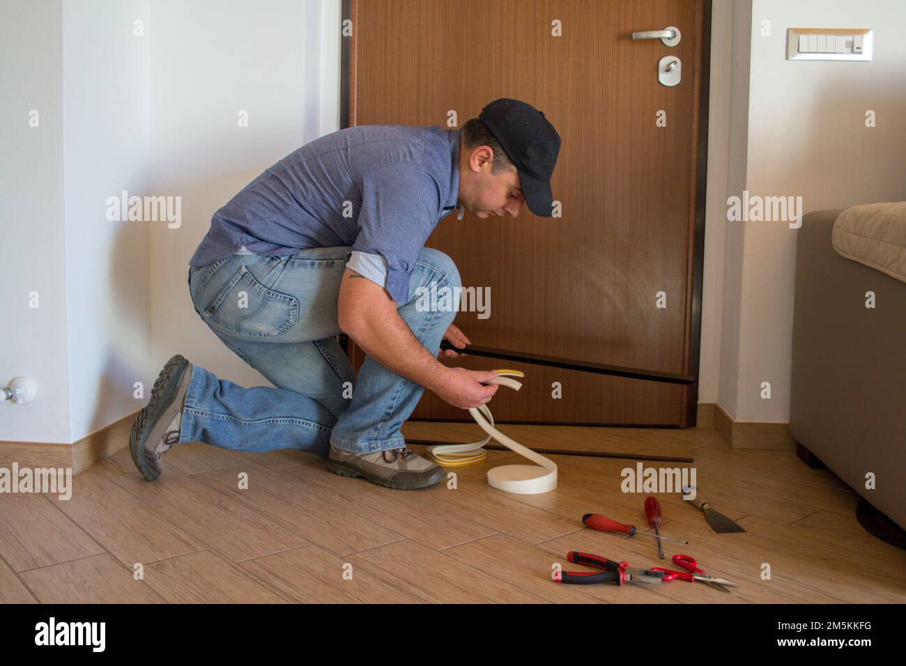 Image of a handyman installing seals and door sills to improve the ...