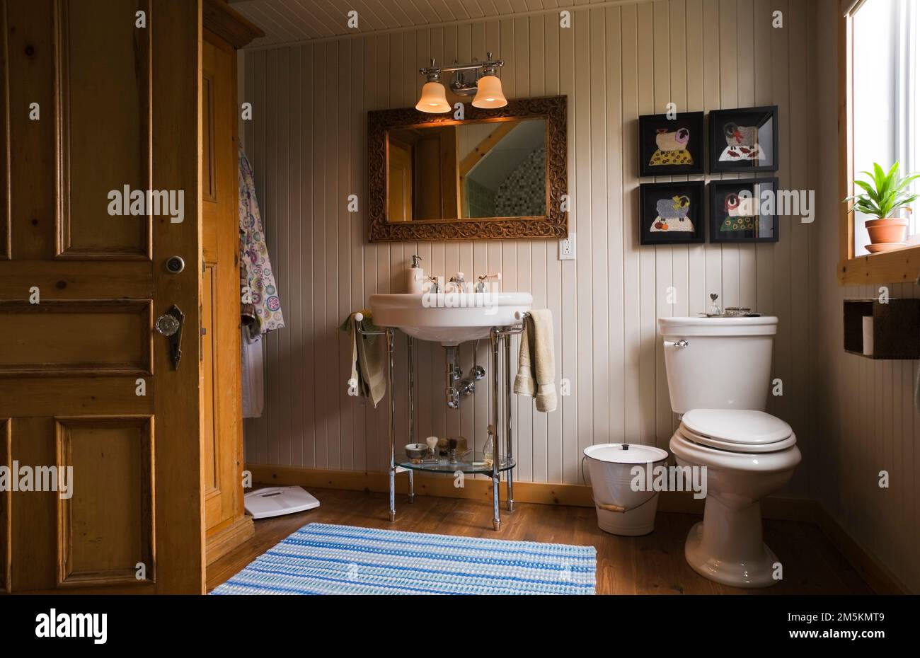 White sink on chrome stand and high tank toilet in main bathroom inside ...