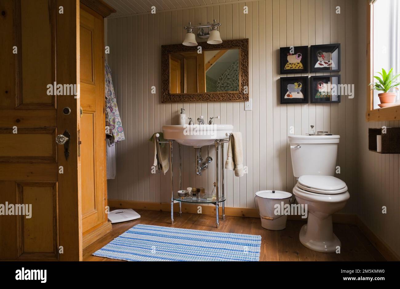 White sink on chrome stand and toilet in main bathroom inside country ...