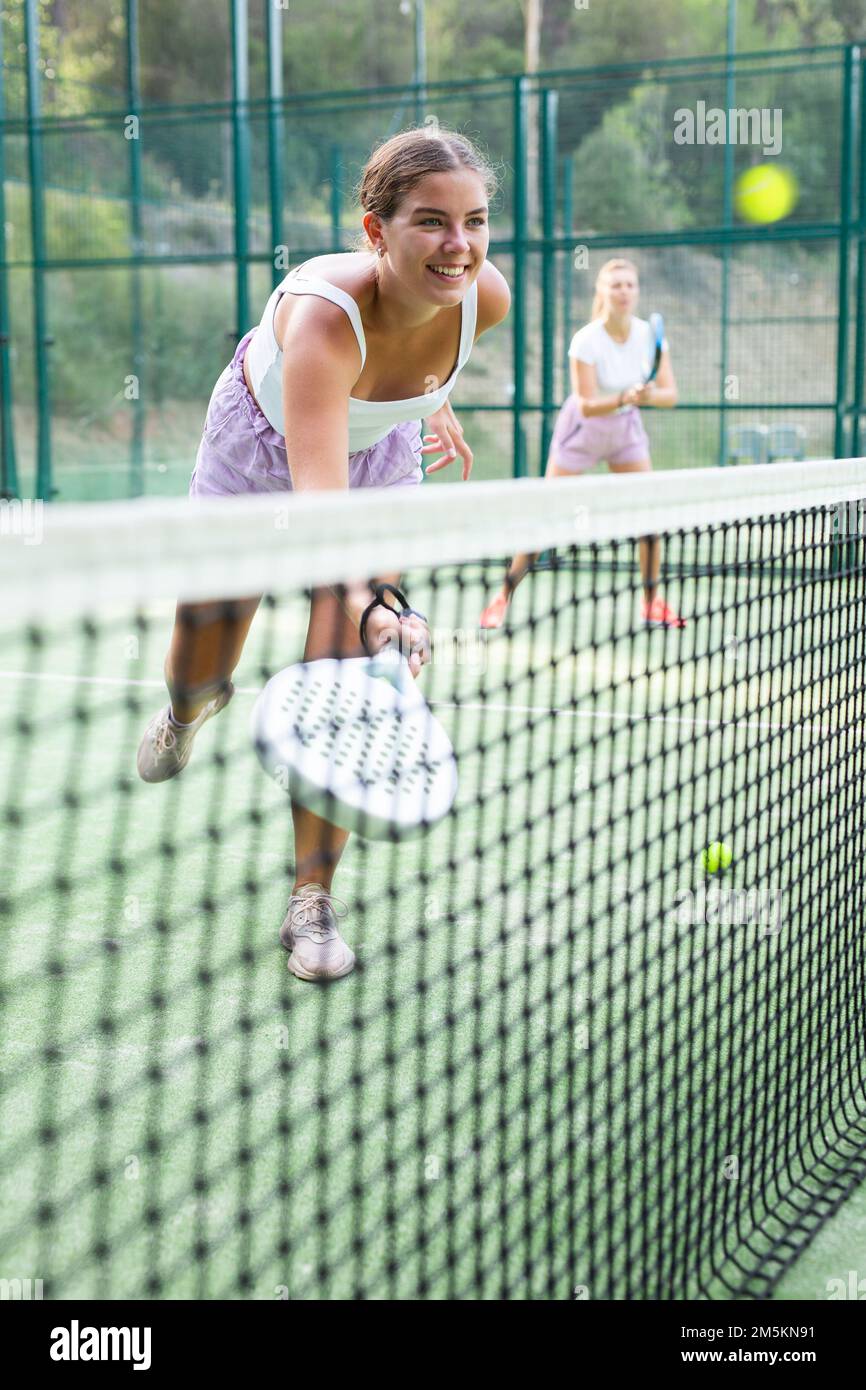 Female player playing padel in a padel court outdoor behind net Stock ...
