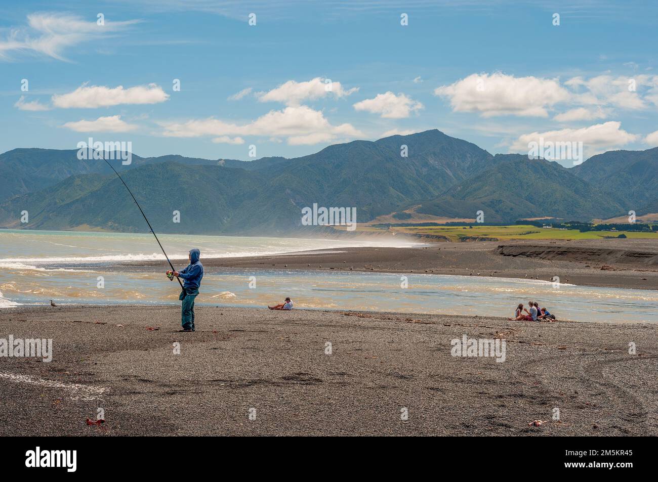 A man fishing on Lake Onoke into Palliser Bay with Orongoronga ...