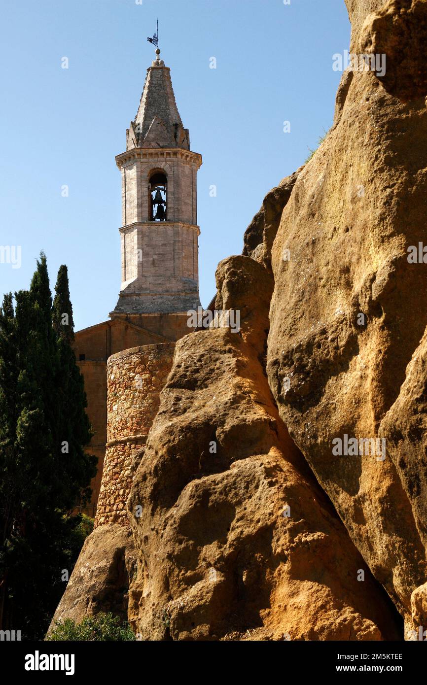 Town wall on top of limestone rocks and tower of Cathedral of Pienza ...