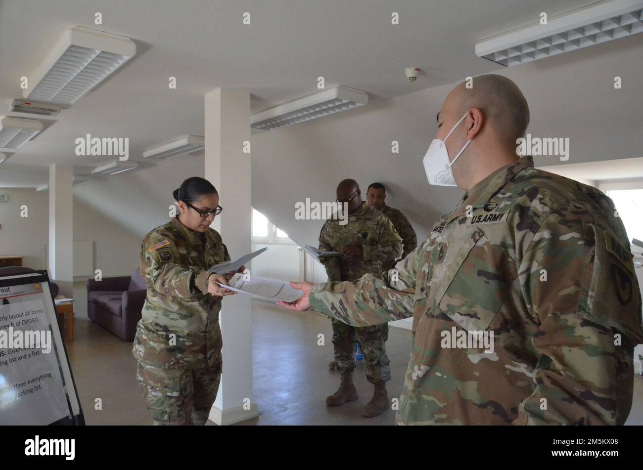 Sgt. 1st Class Diana Isom, left, hands out grading requirements for one ...