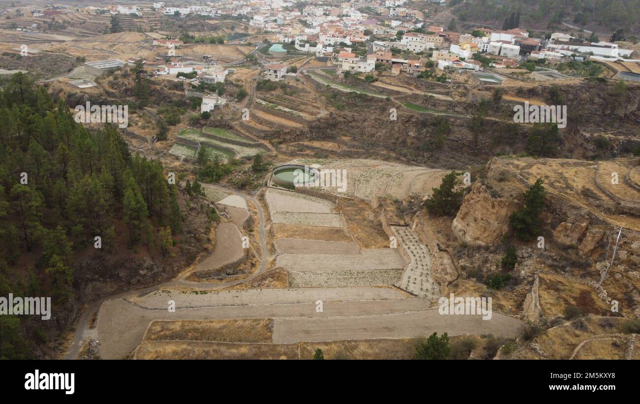 An aerial shot of terrace farms amd irrigation tank on mountainside ...