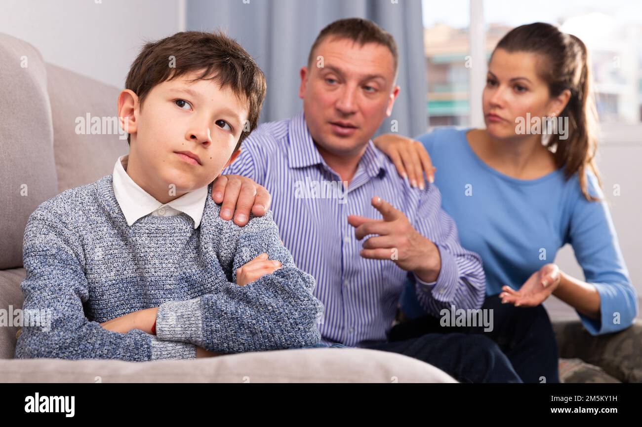 Frowning boy with mother and father berating him Stock Photo - Alamy