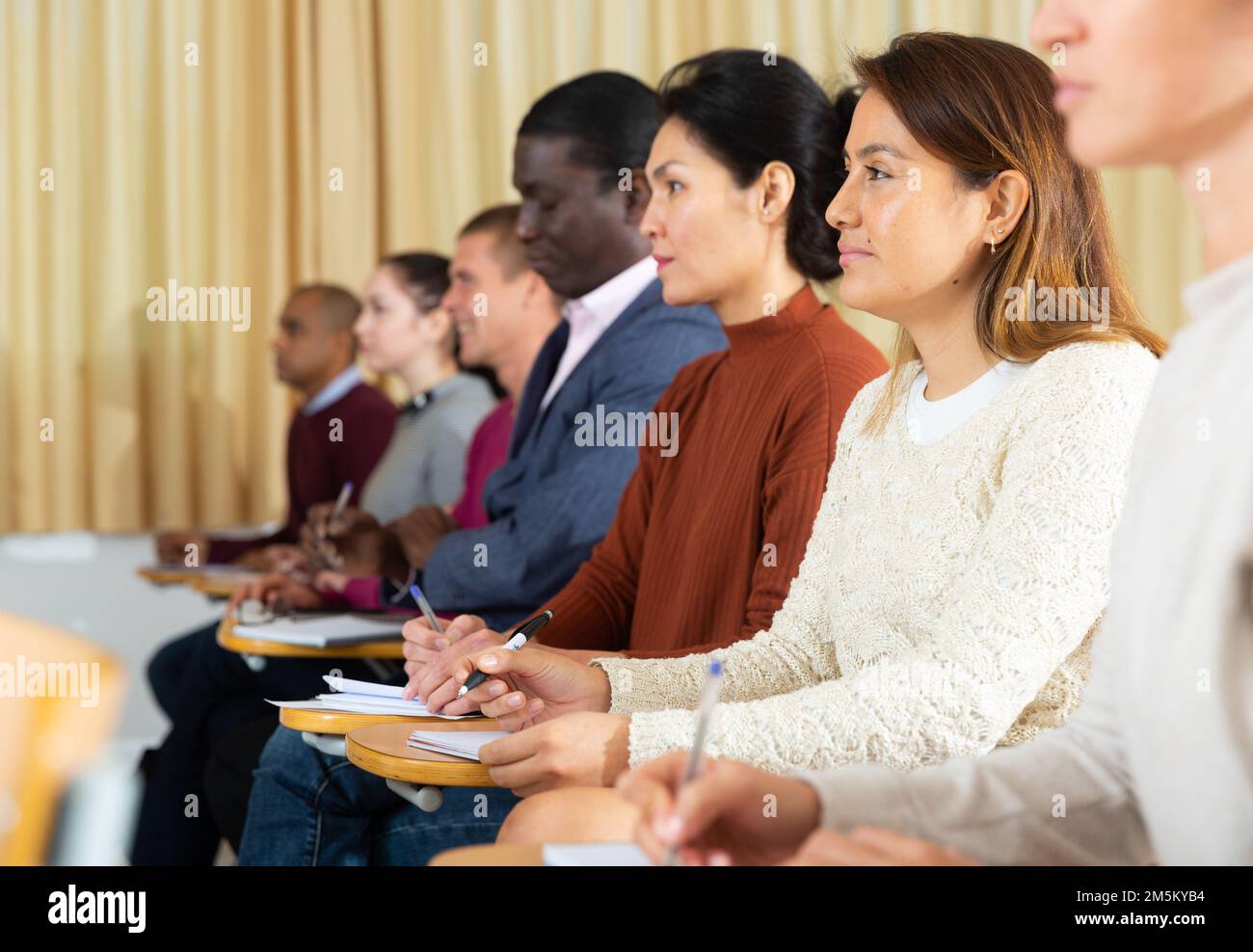 Side view of student group working on lecture in classroom Stock Photo ...