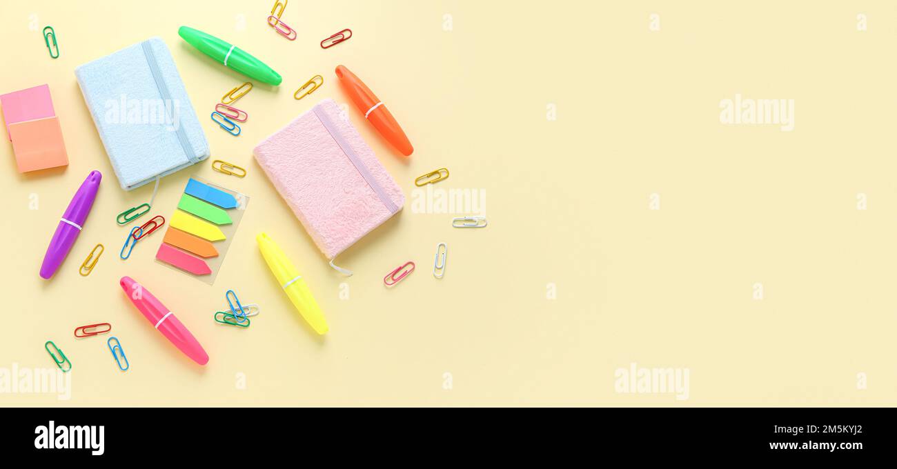 Set of different bright stationery on light yellow background with ...