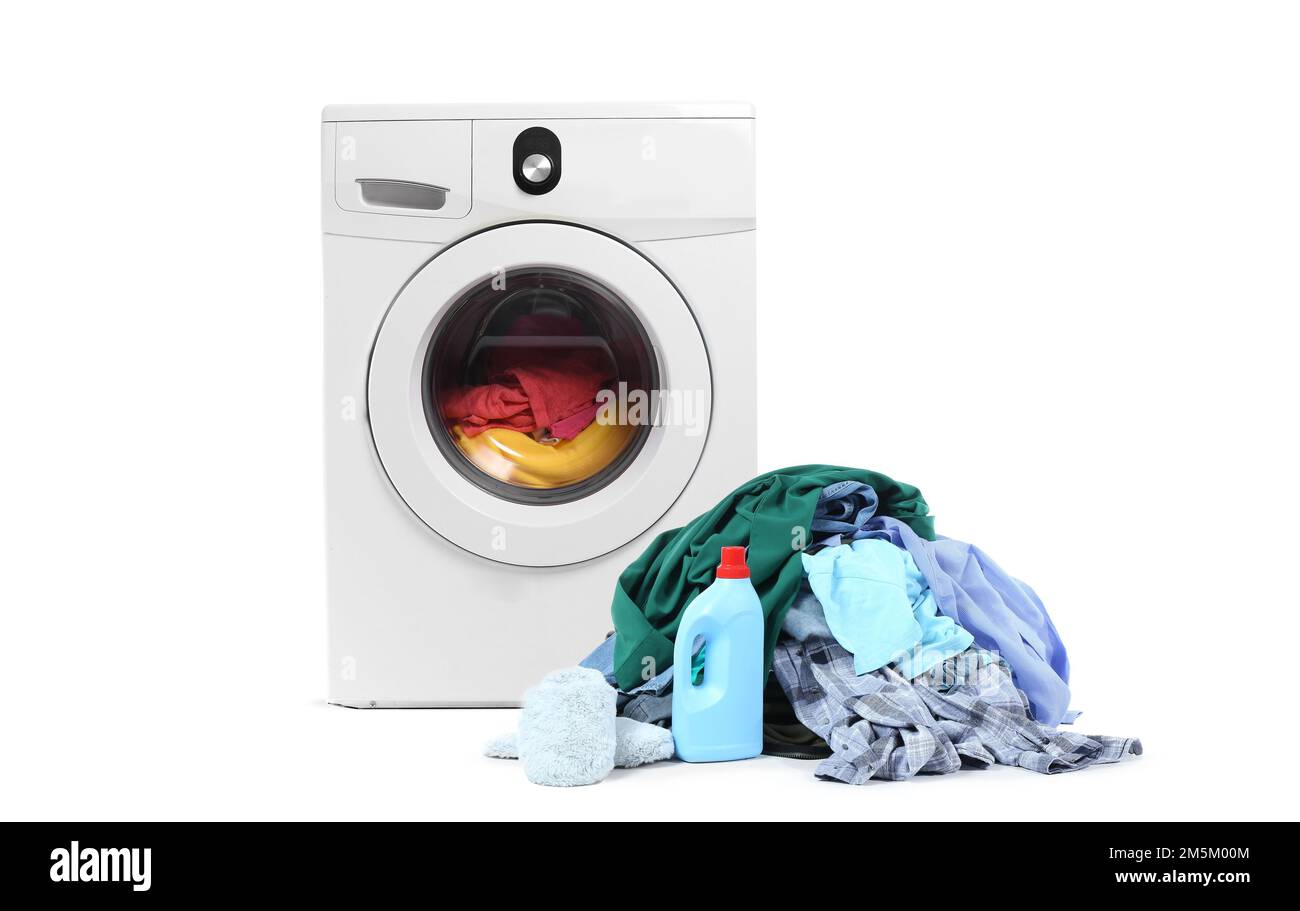 Modern washing machine with heap of dirty clothes and detergent on ...
