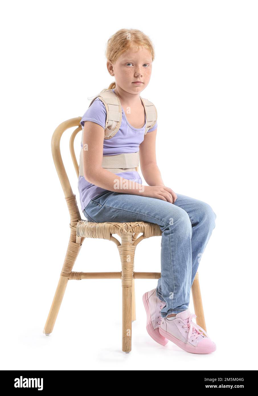 Little girl in back brace sitting on white background Stock Photo - Alamy