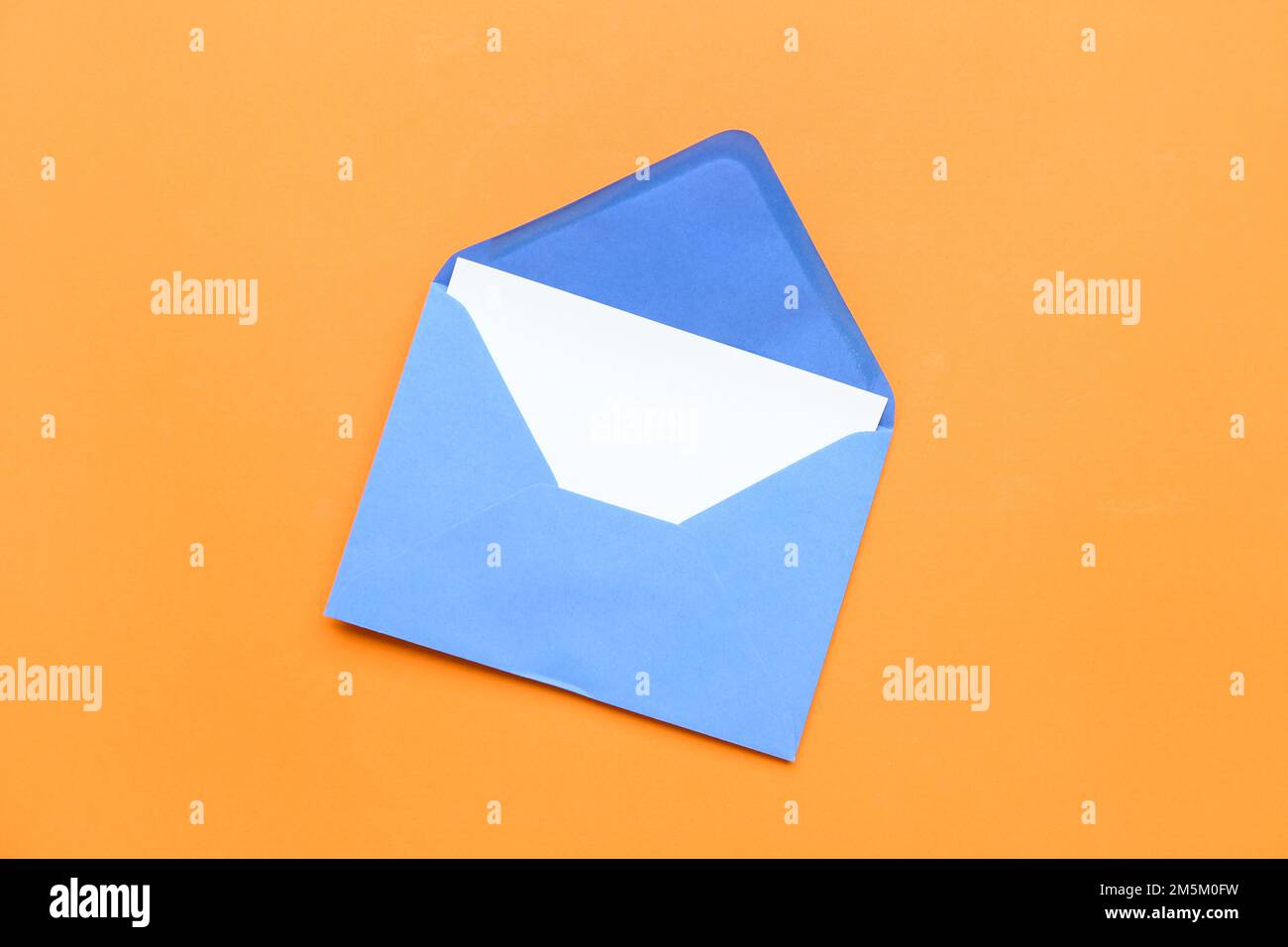 Blue paper envelope with card on color background Stock Photo - Alamy