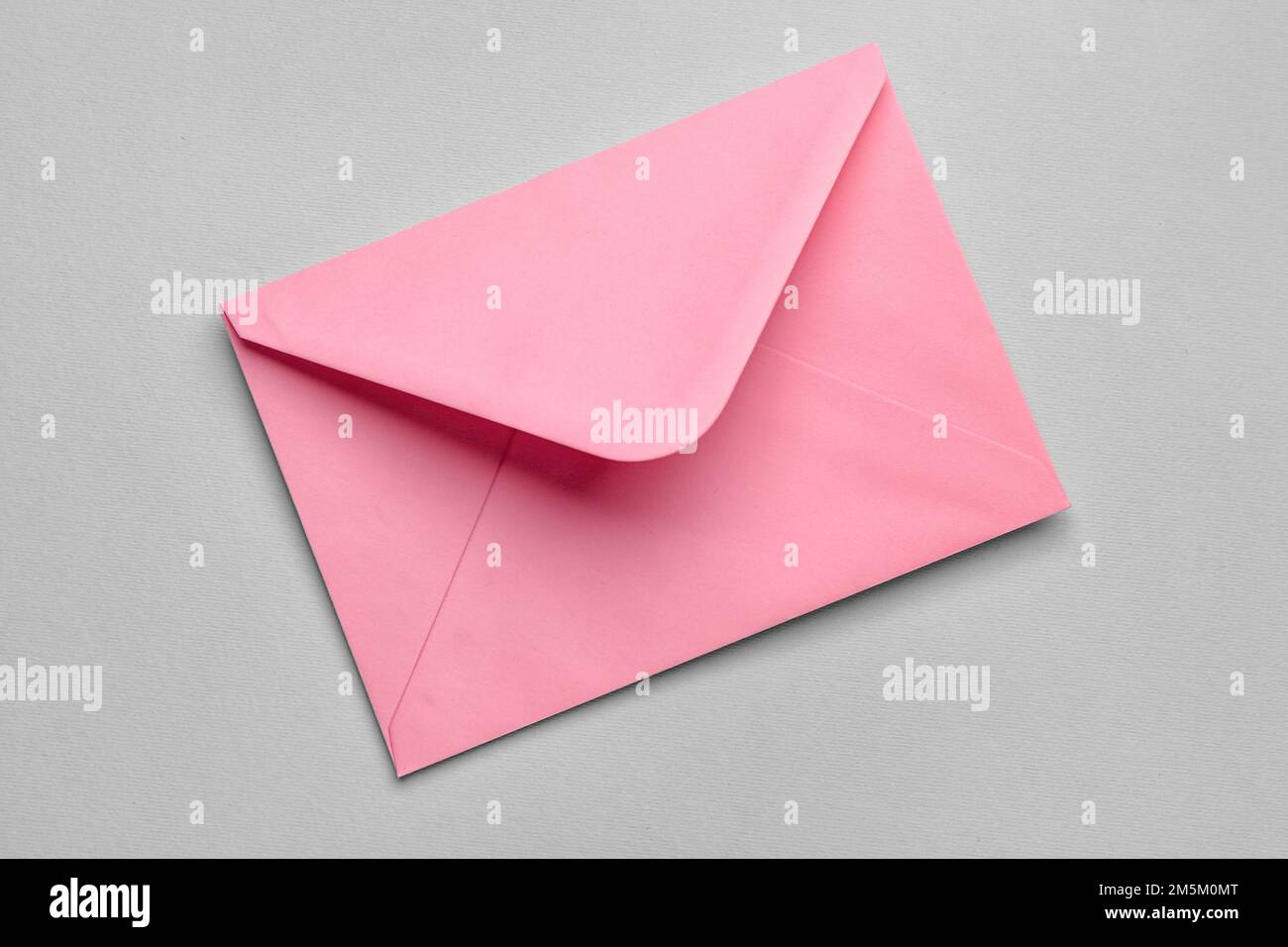 Pink paper envelope on light background Stock Photo - Alamy