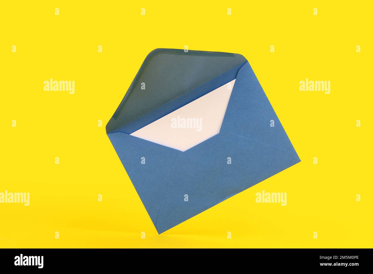Blue paper envelope with card on yellow background Stock Photo - Alamy