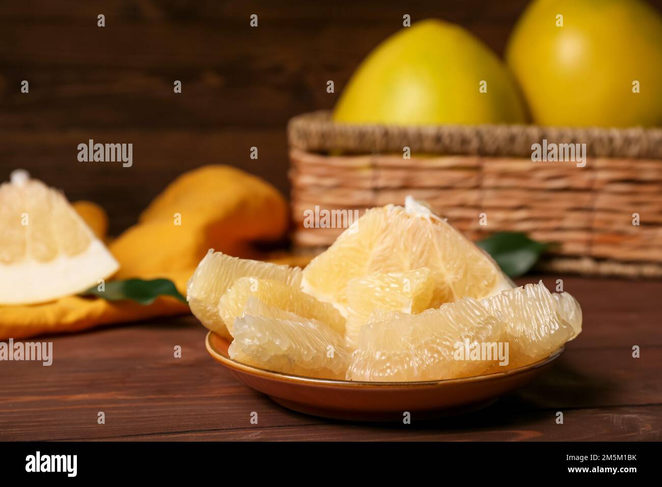 Plate with slices of sweet pomelo fruit on wooden table, closeup Stock ...