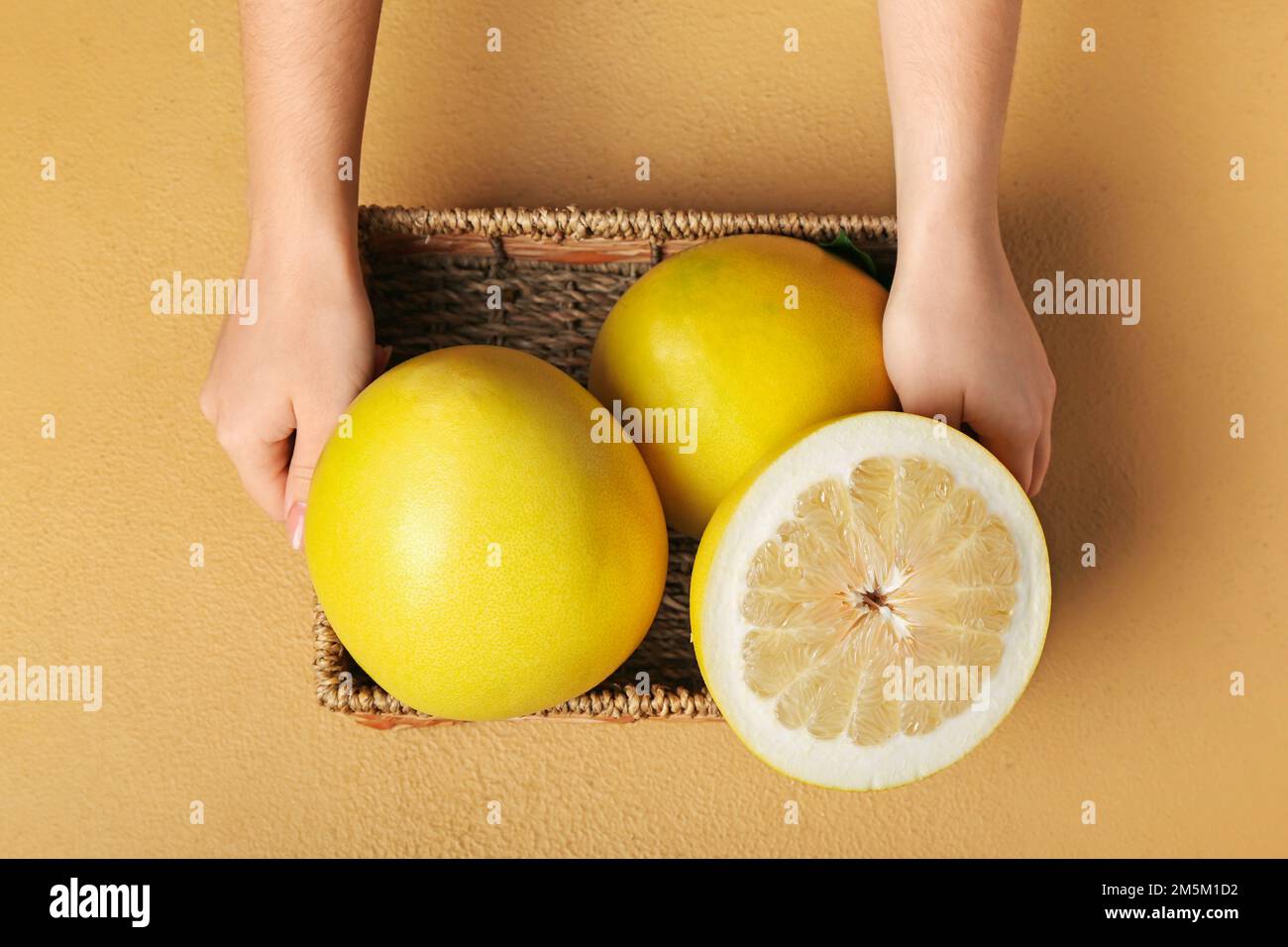Female hands with sweet pomelo fruits on beige background Stock Photo ...