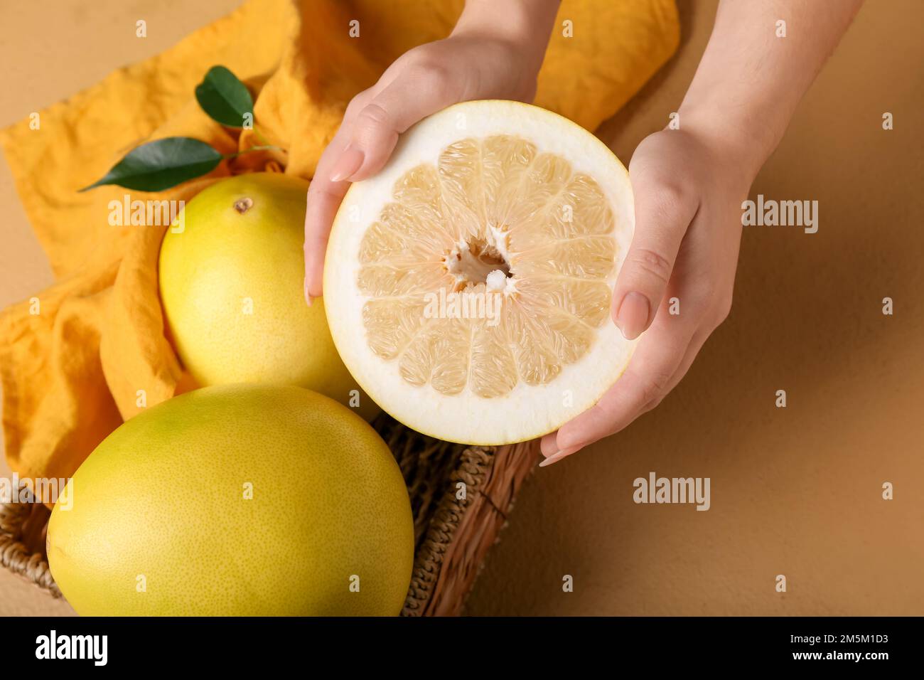 Female hands with sweet pomelo fruits on beige background, closeup ...