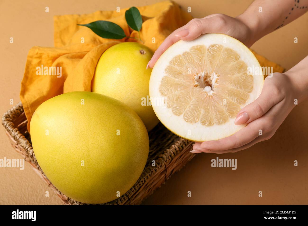Female hands with sweet pomelo fruits on beige background, closeup ...
