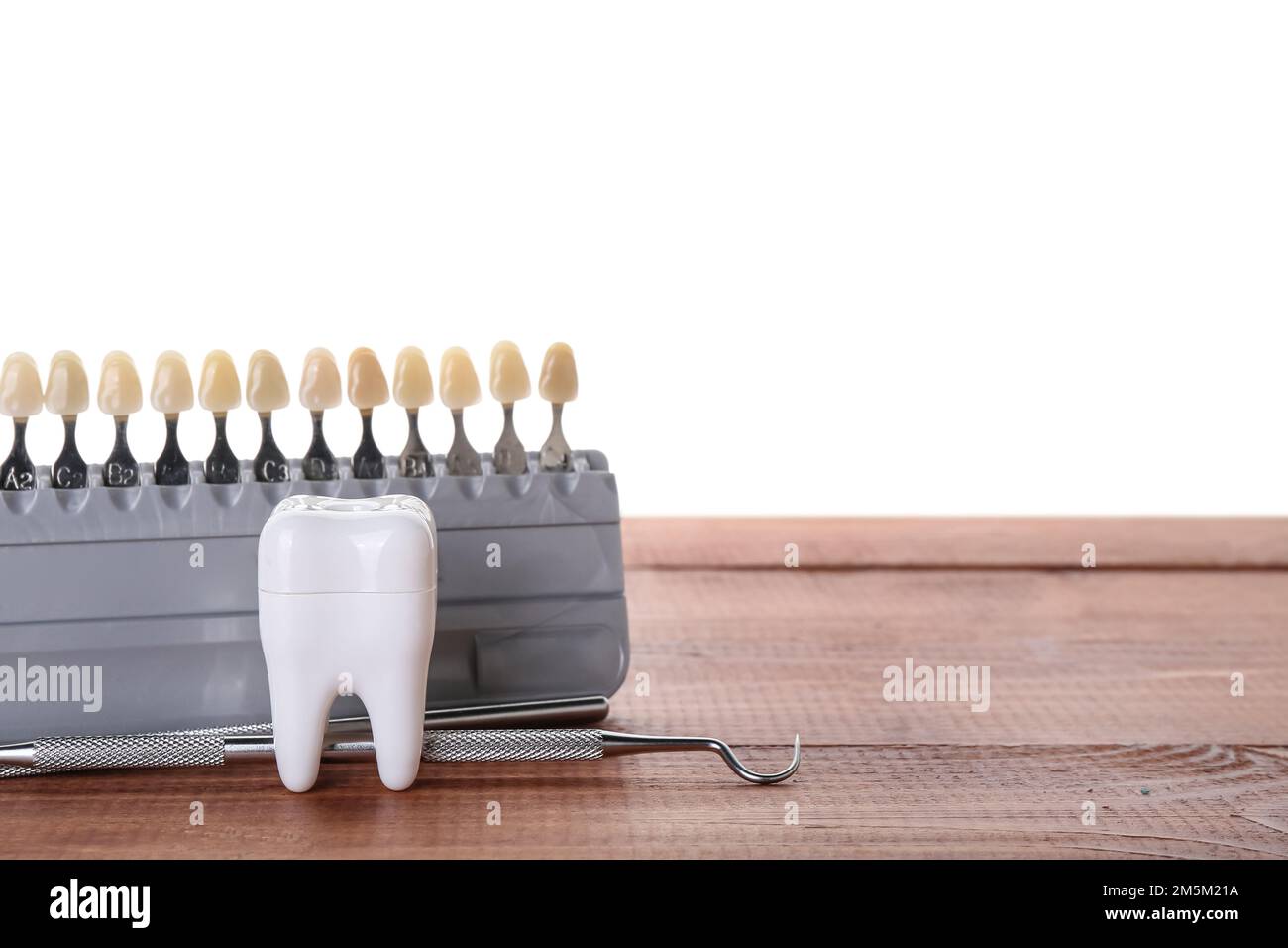 Teeth color samples with dental tools on table against white background ...