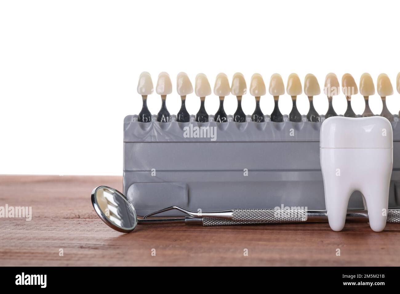 Teeth color samples with dental tools on table against white background ...