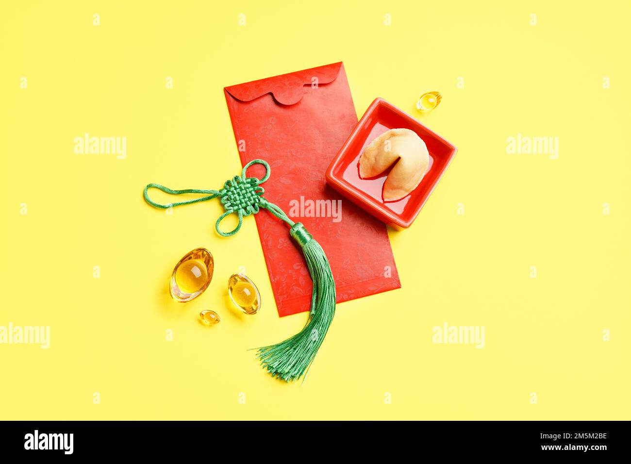 Red envelope, fortune cookie and Chinese symbols on yellow background ...