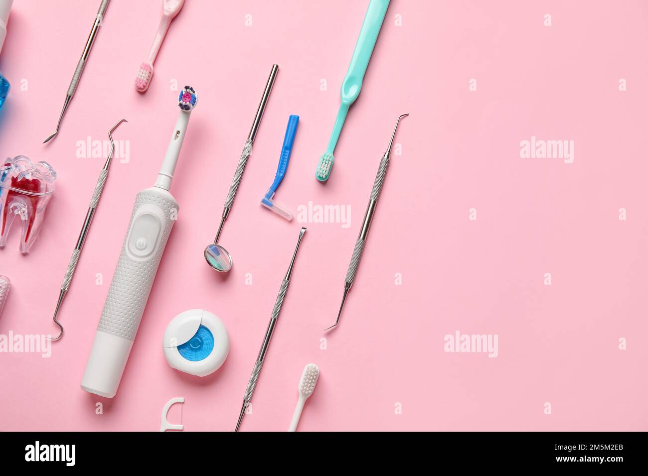Dental tools with toothbrushes on pink background Stock Photo - Alamy