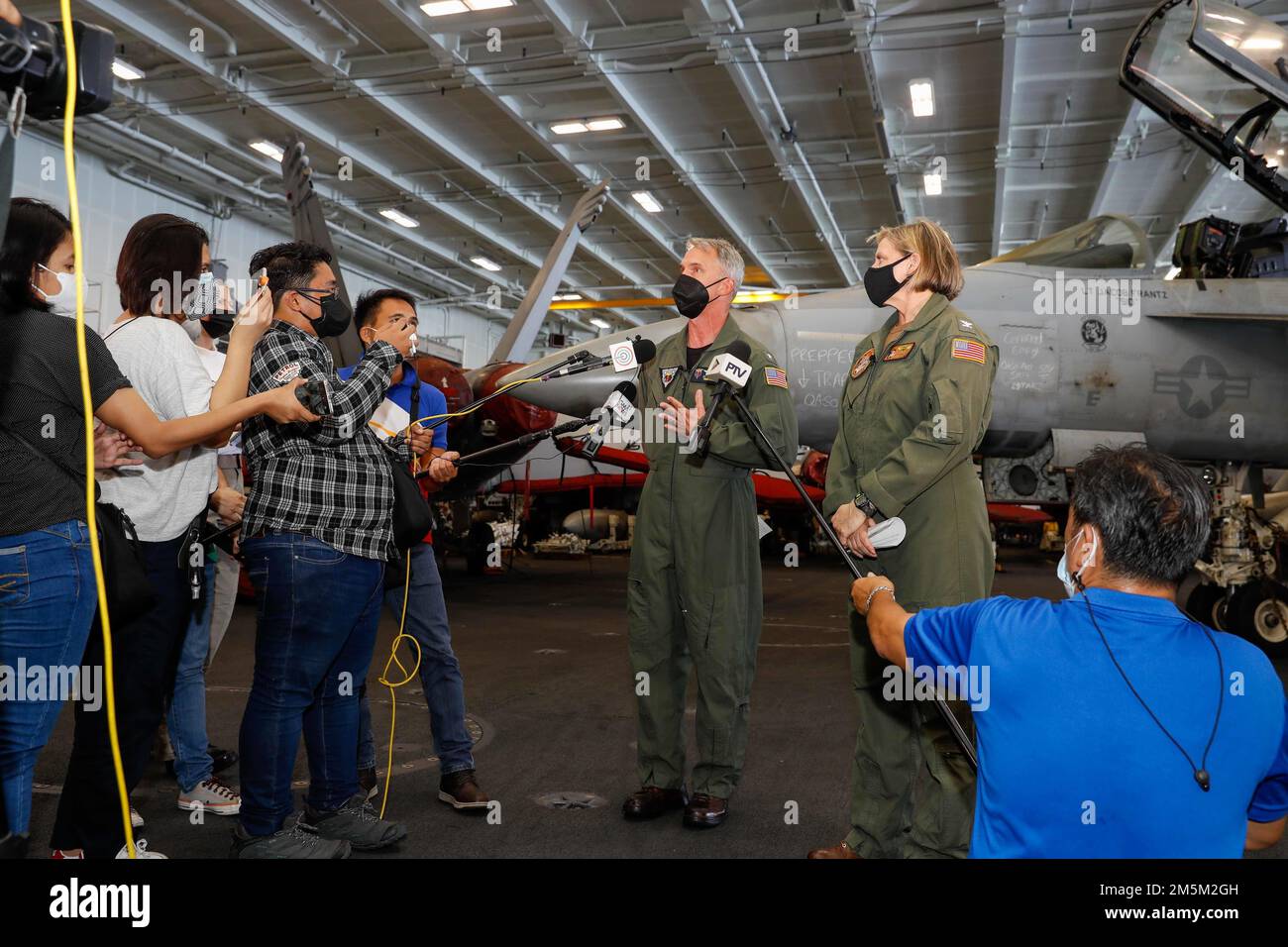 SOUTH CHINA SEA (March 24, 2022) Rear Adm. J.T. Anderson, center, commander, Carrier Strike ...