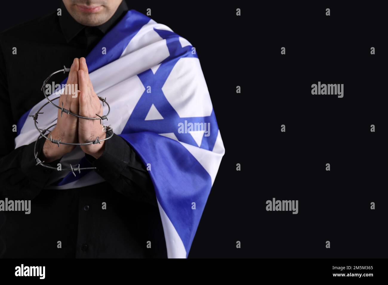 Praying Jewish man with flag of Israel and barbed wire honoring victims ...