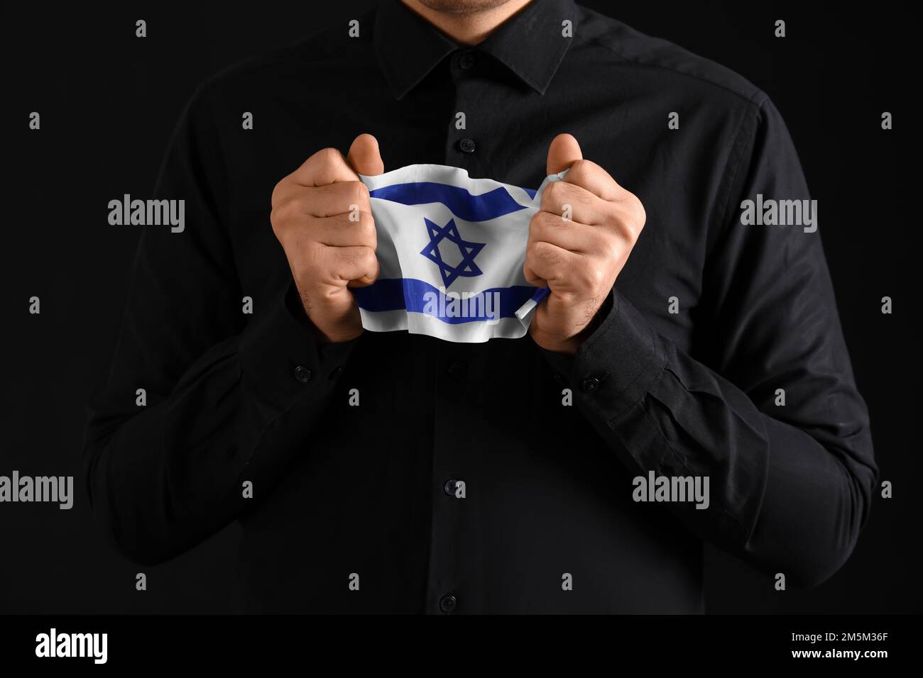 Jewish man with flag of Israel honoring victims of Holocaust on dark ...
