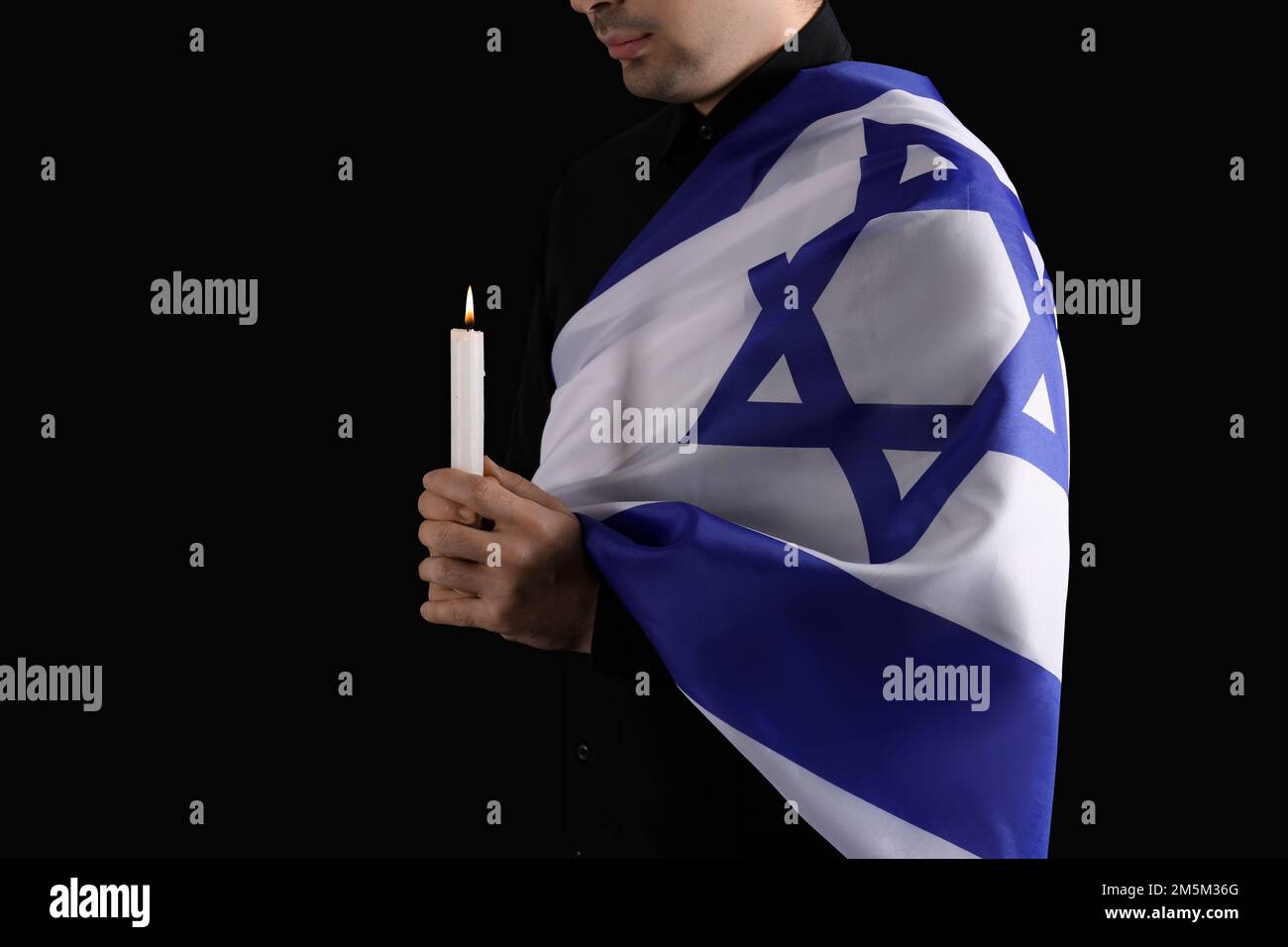 Jewish man with candle and flag of Israel honoring victims of Holocaust ...