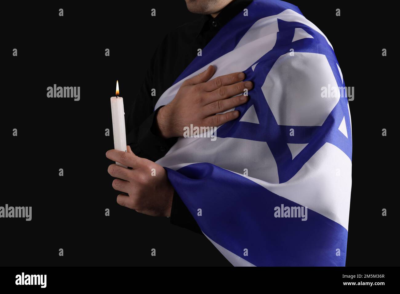 Jewish man with candle and flag of Israel honoring victims of Holocaust ...