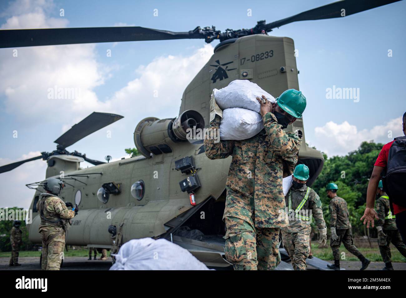 A member of Panama’s SENAFRONT offloads a bag of gravel from a CH-47 ...