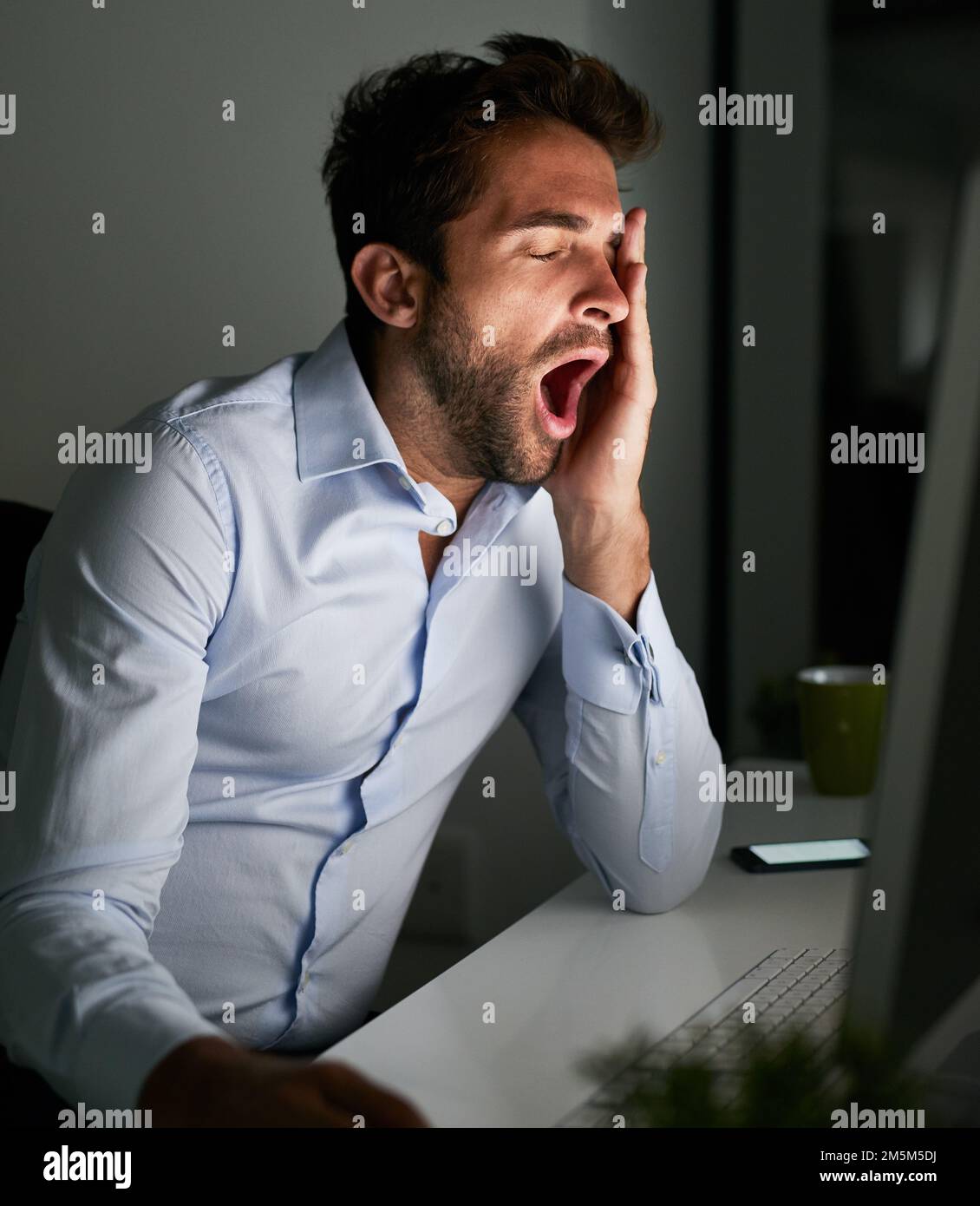 Putting in the hours to achieve success. a young businessman working ...