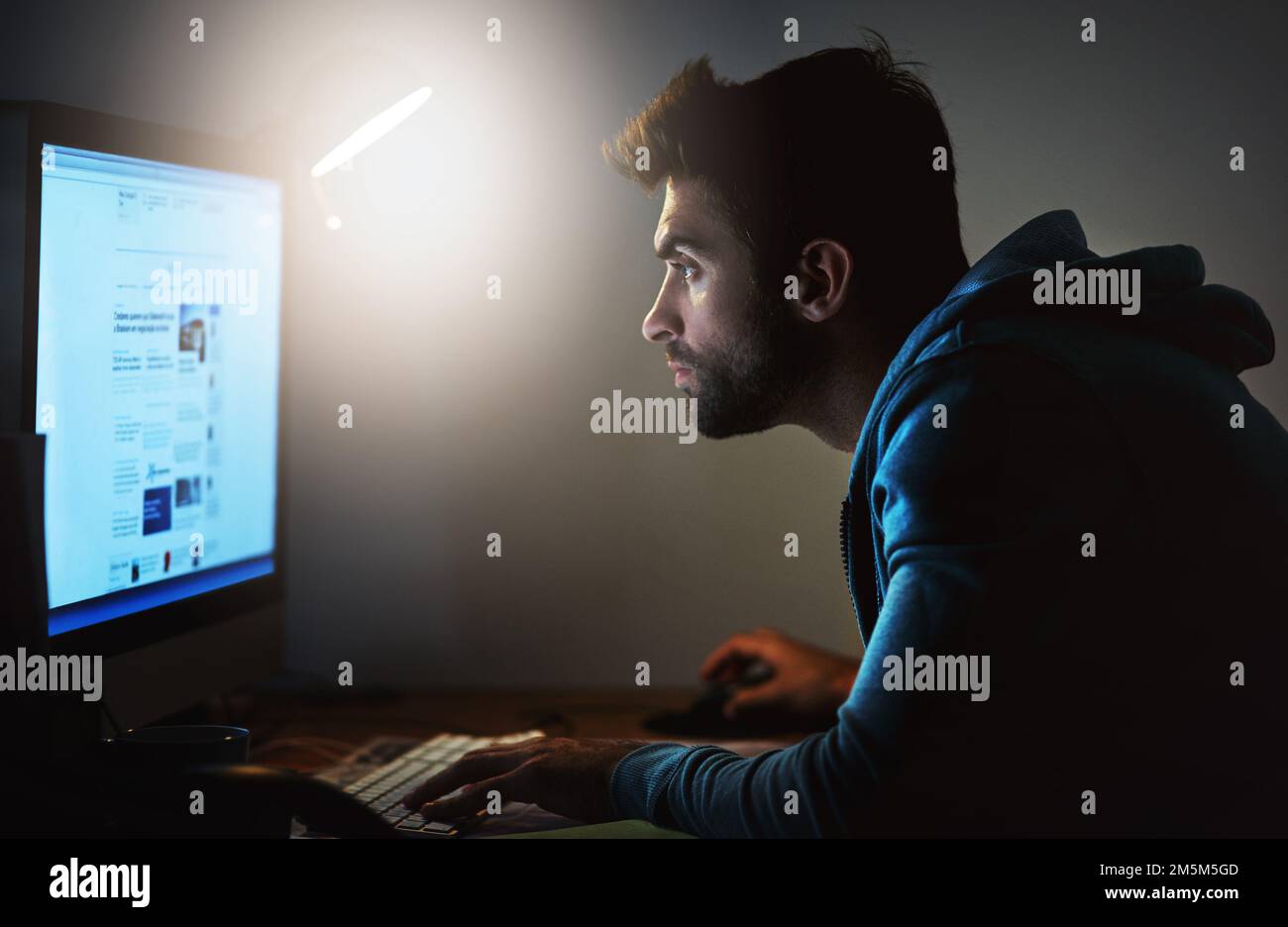 Pulling an all-nighter. a young designer working late in the office ...