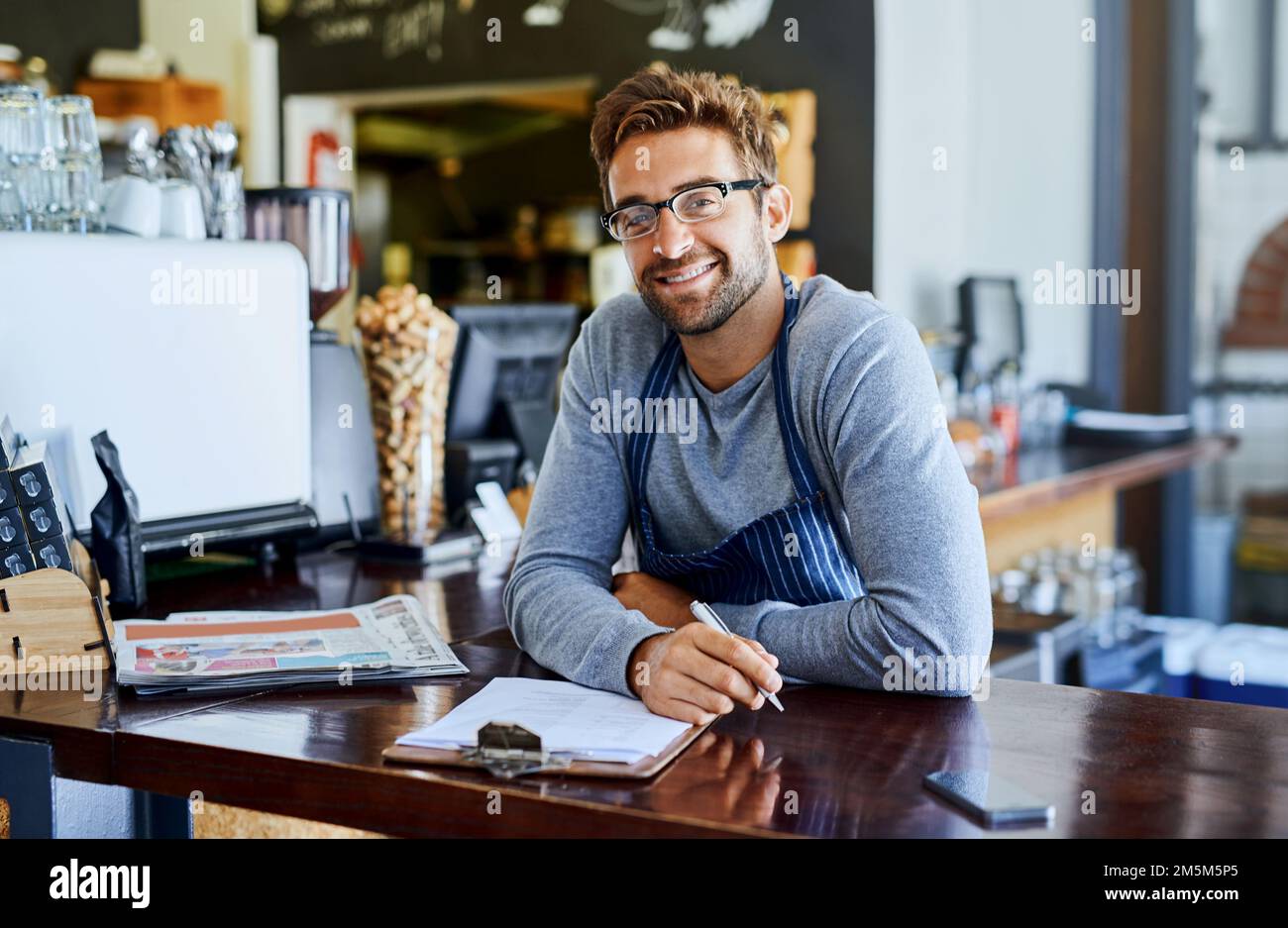 Another profitable month. a handsome young coffee shop owner going over ...