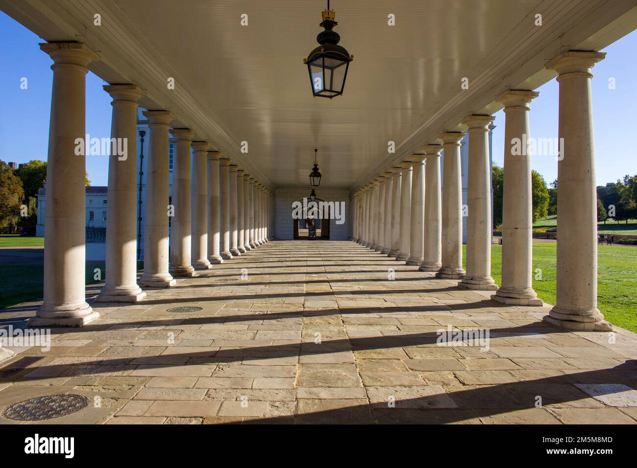 A long alley with pillars of an old architecture during a sunny day ...