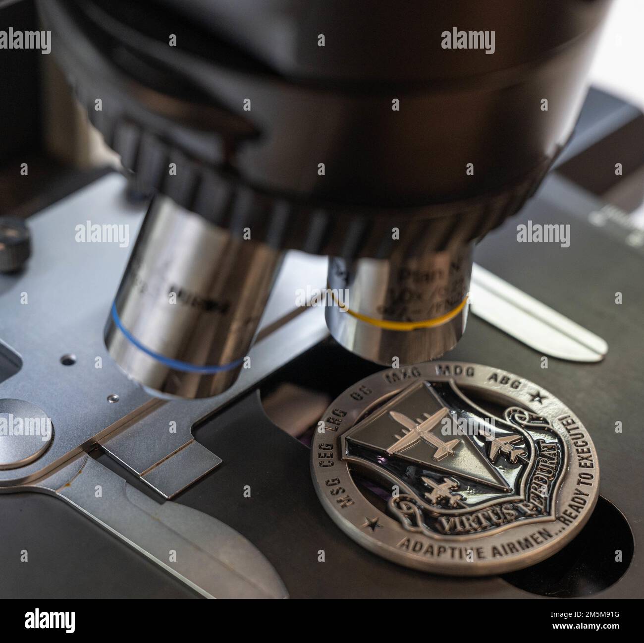 An Airlifter of the Week Coin sits on a microscope at Ramstein Air Base ...