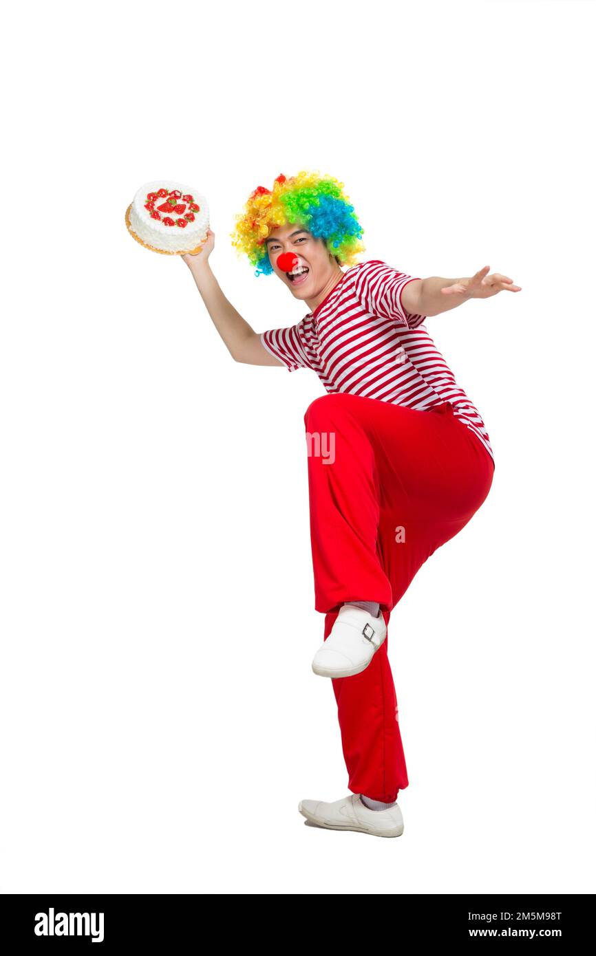 Shed happy funny clown, with cake Stock Photo - Alamy