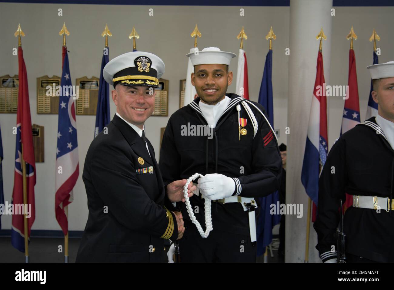 220325-N-ZZ000-1004 (March 4, 2022) Fireman Parker Mitchell, right, receives his aiguillette ...