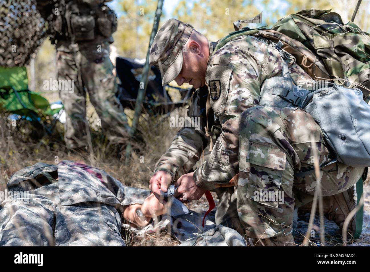 Staff Sgt. Christopher Wall, applies a bandage during the Army Warrior ...