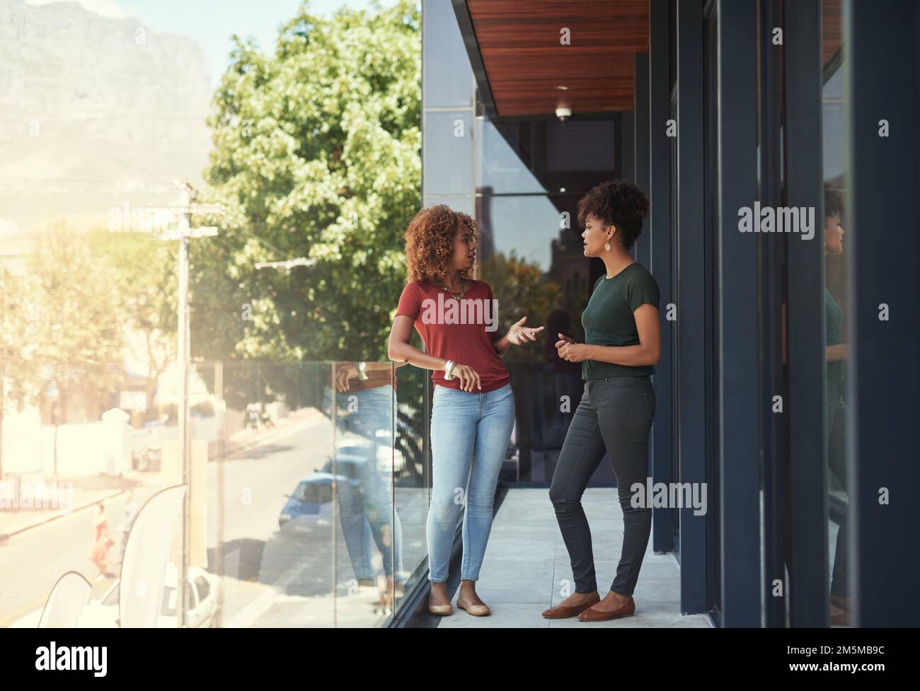 Communication in the workplace is important. two businesswomen chatting ...
