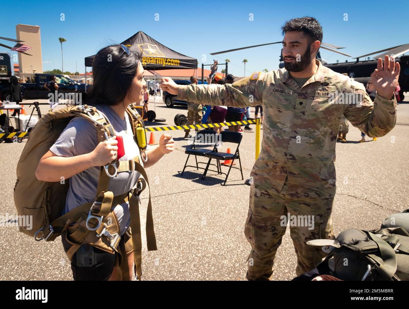 After helping his visitor put on a T-11 Parachute Pack, U.S. Army Spc ...