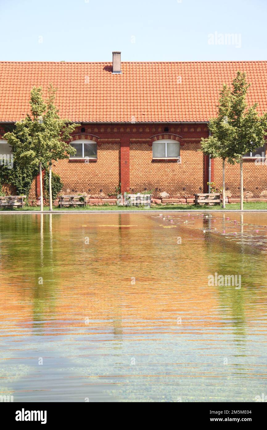 Water reservoir with a built of red brick building in the background ...