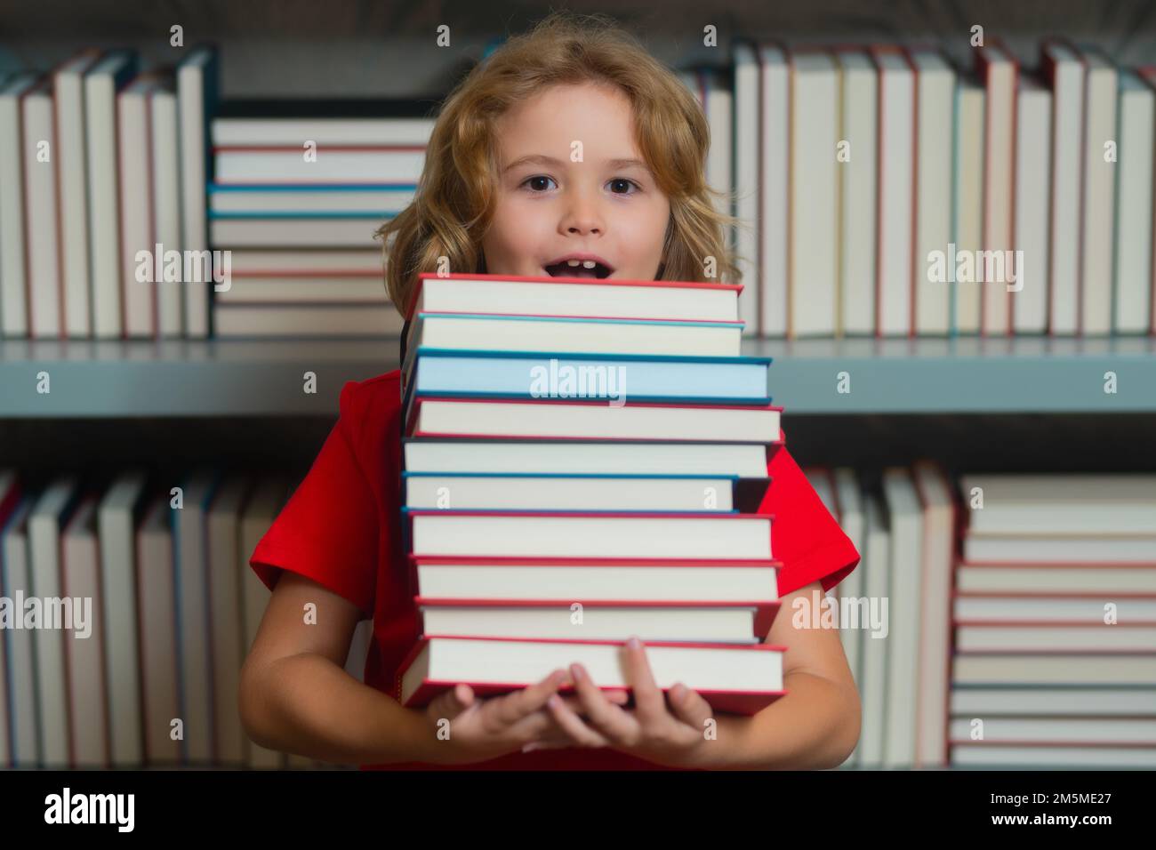 Excited school kid hold stack of books. Surprised school kid. Schoolboy ...