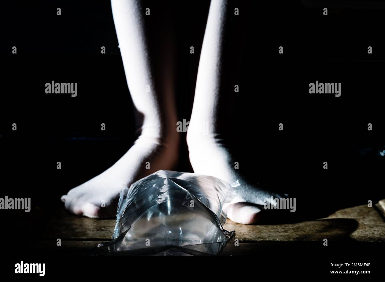 Focus on feet of a child standing on top of bubble wrap that has been ...