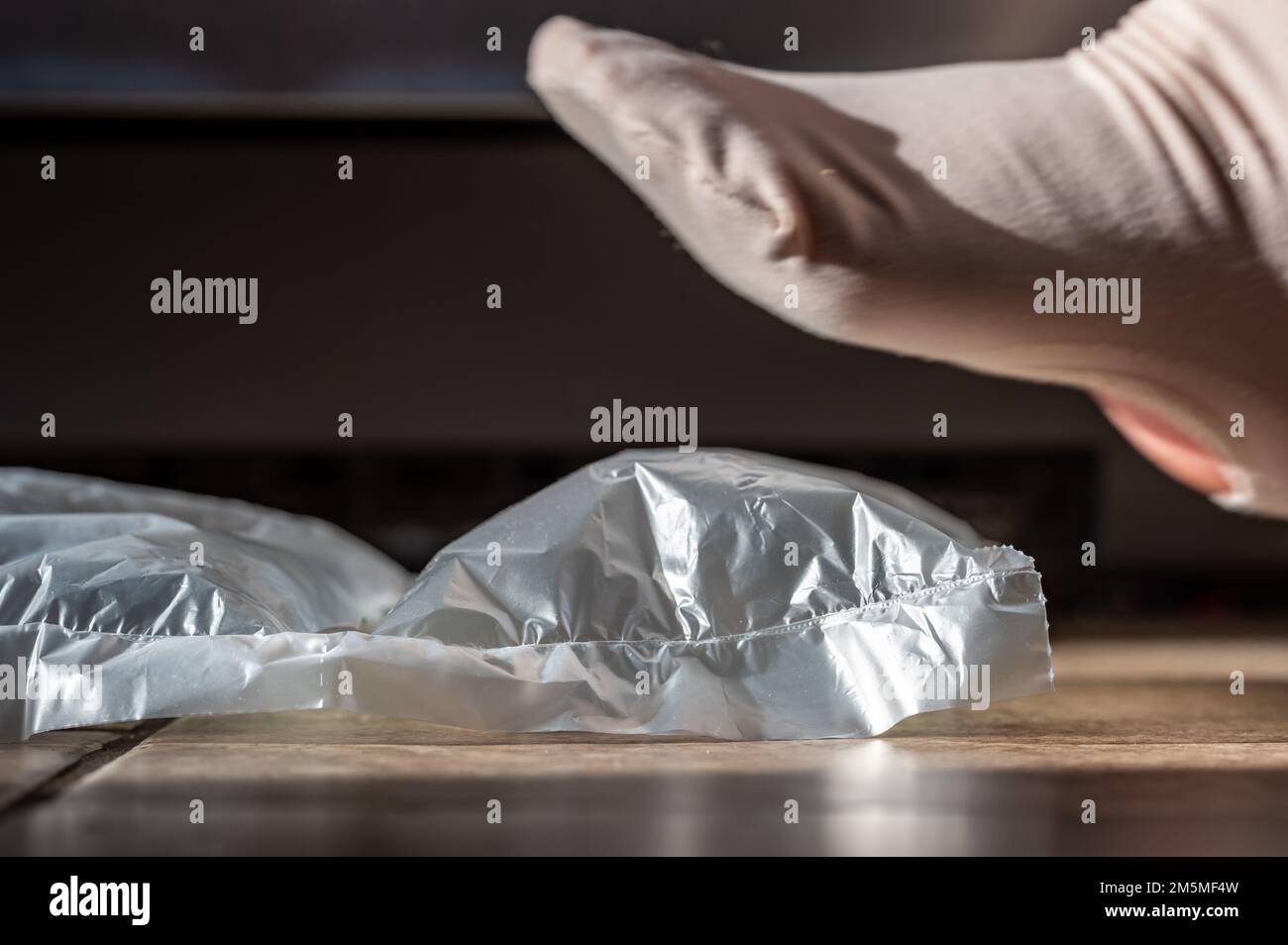 Focus on feet of a child standing on top of bubble wrap that has been ...